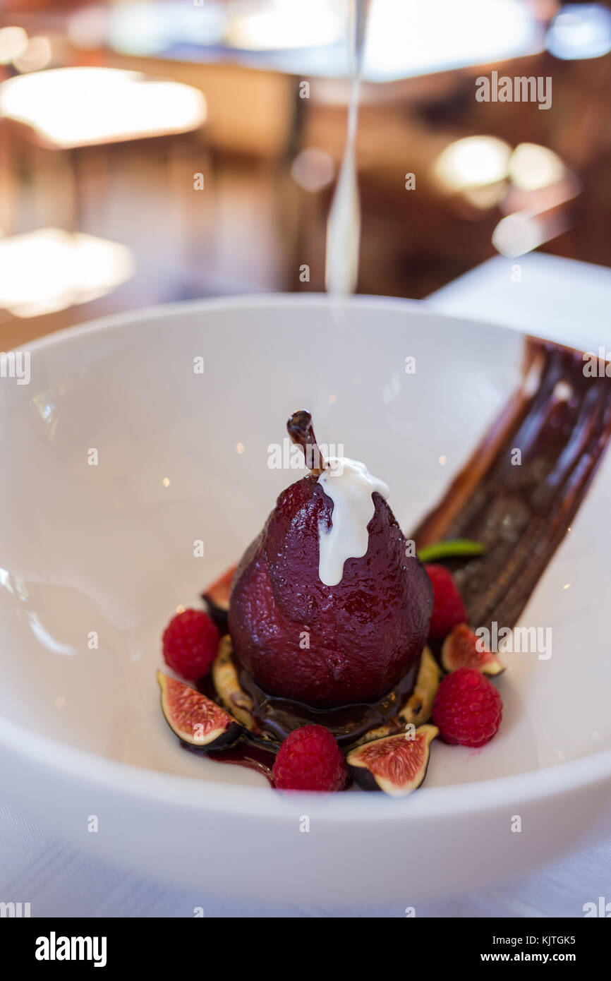 Red wine poached pear from a gourmet restaurant plated on a chocolate ...