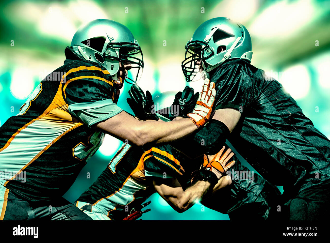 Struggling football player pushing each other in front of a light ...