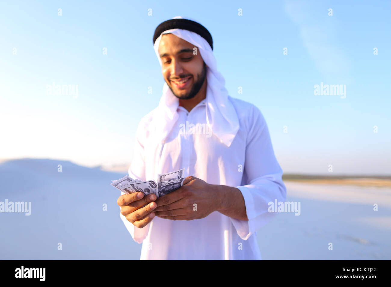 Successful Arab sheikh considers banknotes and happy, standing i Stock ...