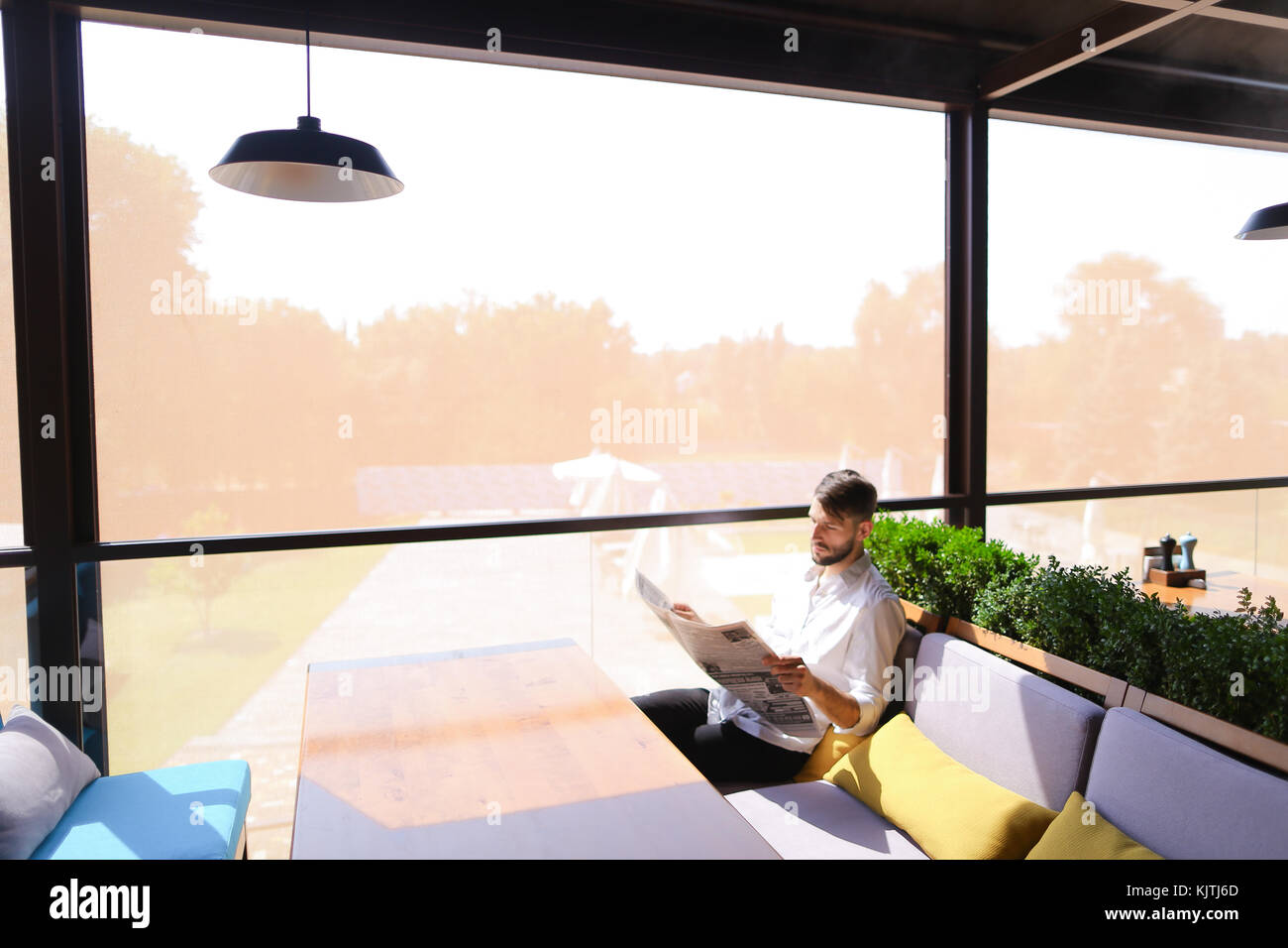 Prosperous man reading newspaper articles and resting Stock Photo - Alamy