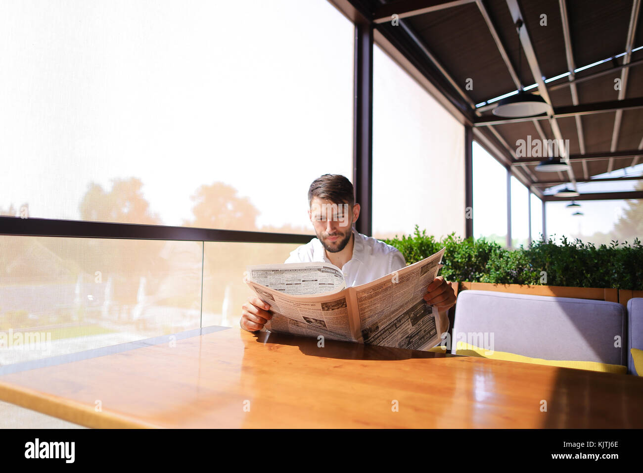 Prosperous man reading newspaper articles and resting Stock Photo - Alamy
