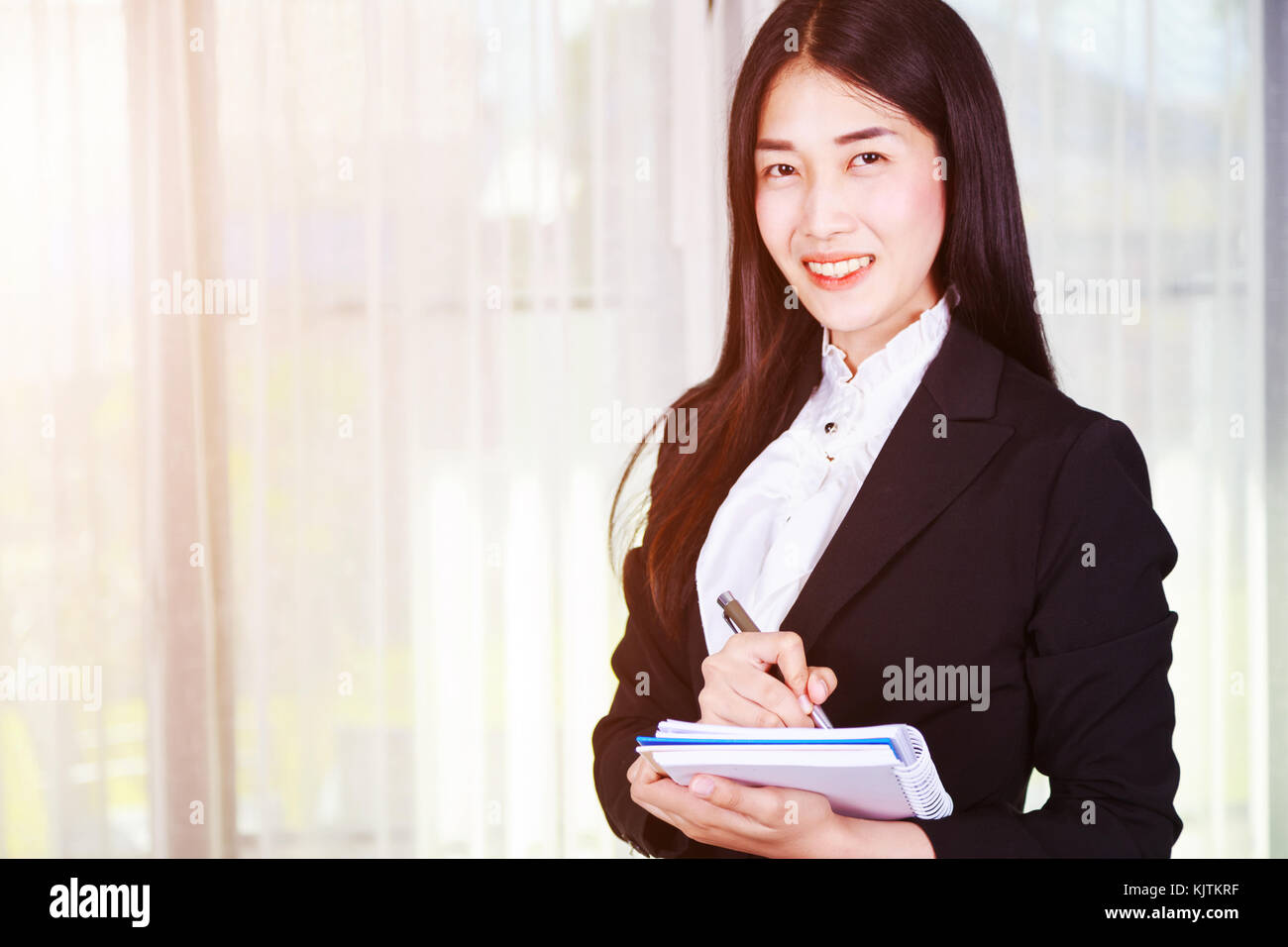 young business women standing and writing down on notebook Stock Photo ...