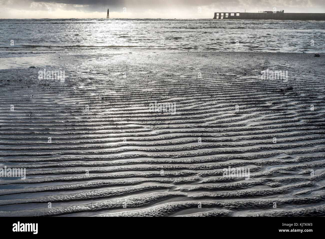 Tide going out, creating ripples in sand by English Channel, with pier ...
