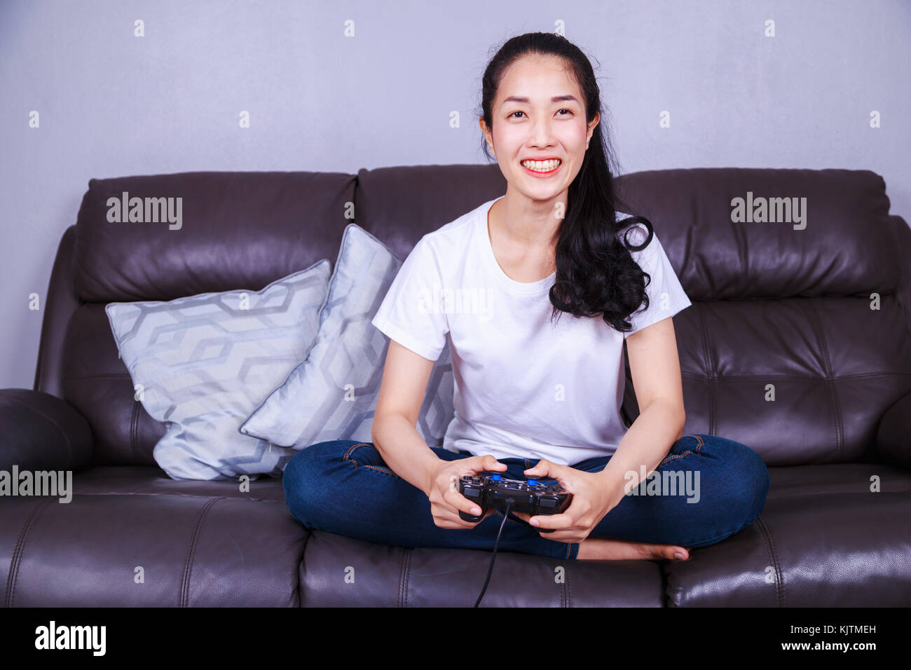 woman using joystick controller playing video game on sofa in living ...