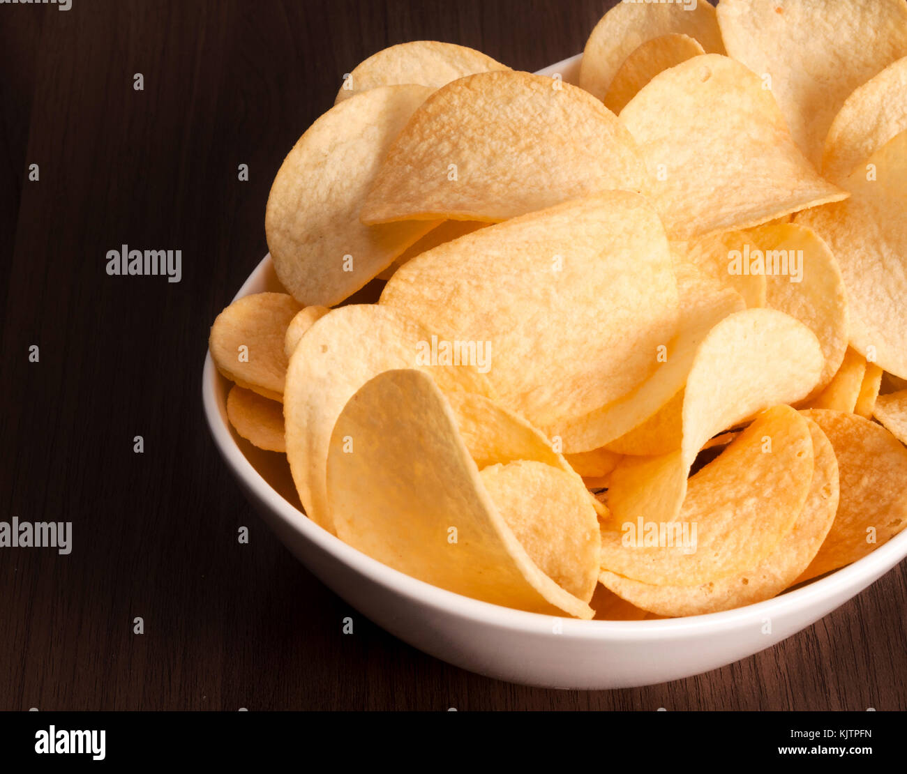 Potato chips in the white cup in low key Stock Photo - Alamy