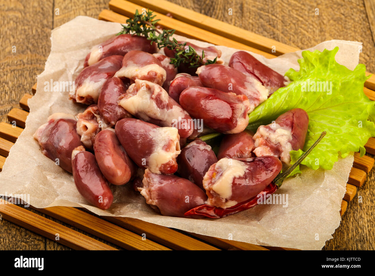 Raw chicken hearts heap with thyme branch Stock Photo - Alamy
