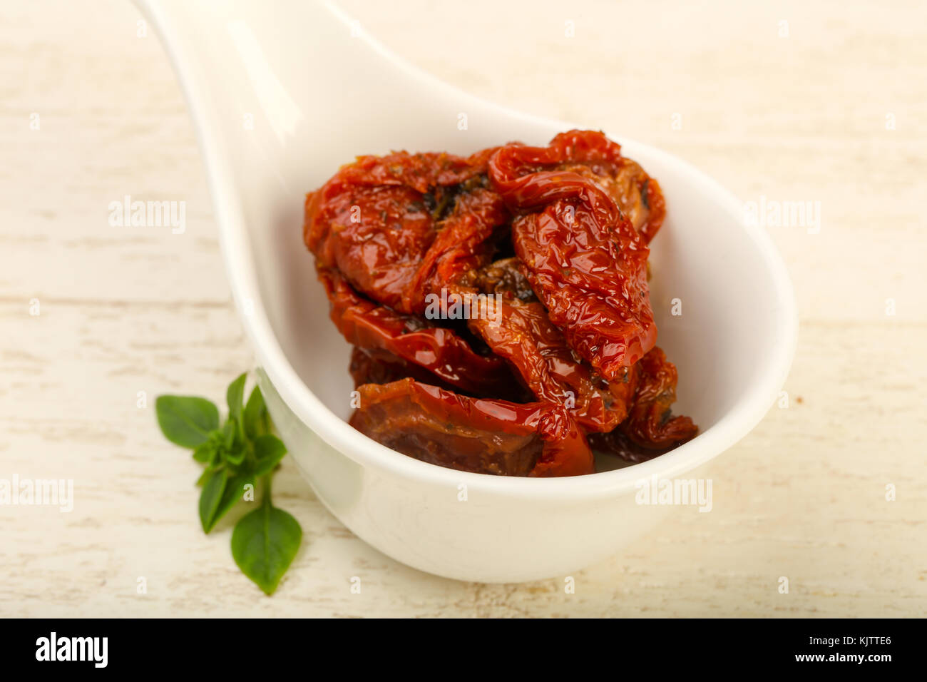 Dried tomato in olive oil with basil leaves Stock Photo - Alamy