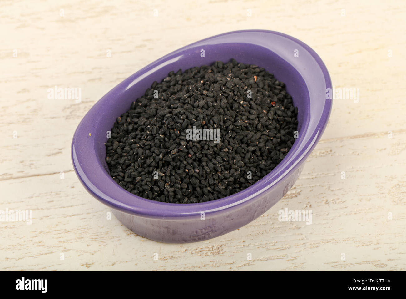 Black nigella seeds heap over wooden background Stock Photo - Alamy