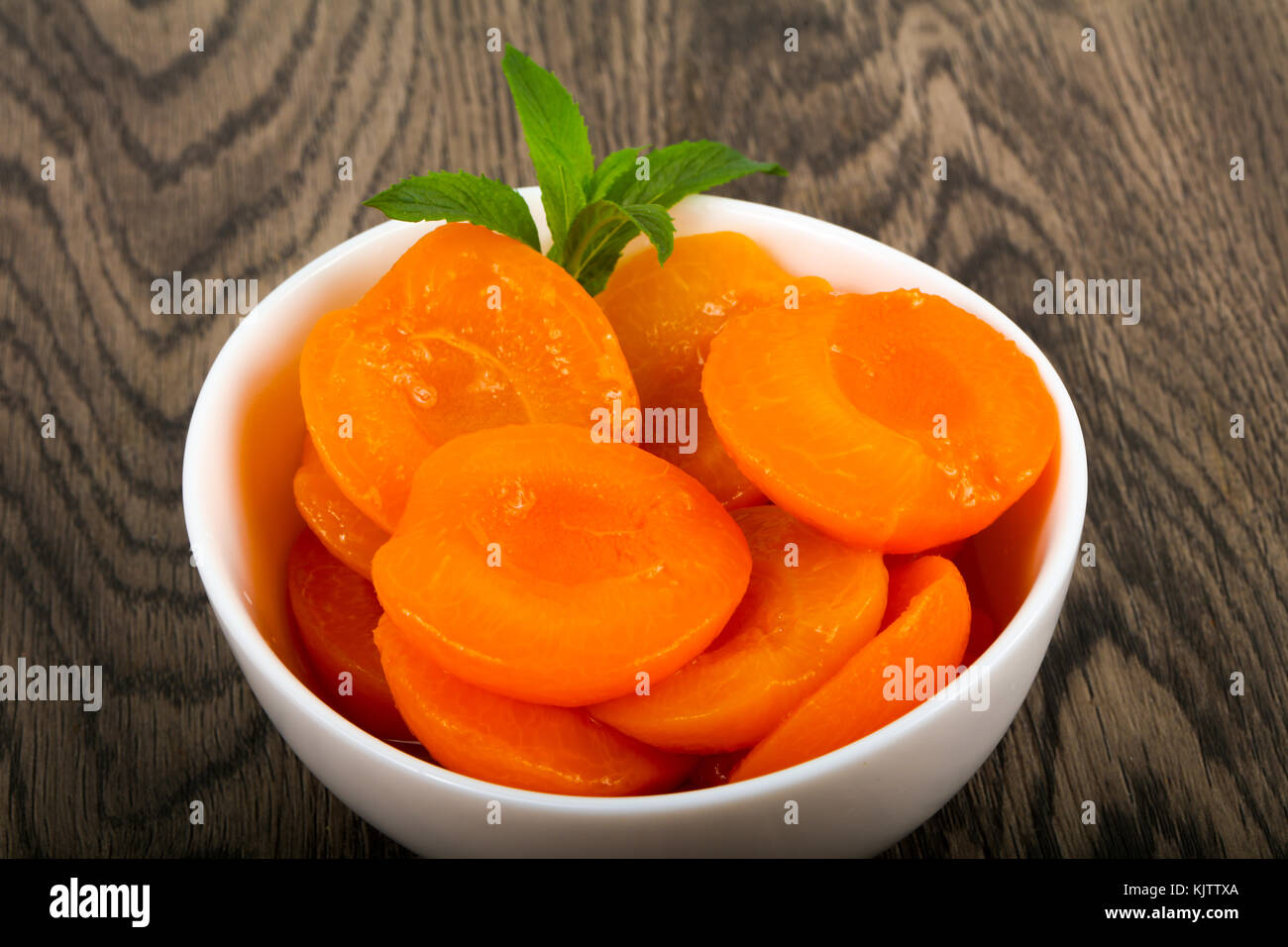 Canned apricots with mint leaves Stock Photo - Alamy