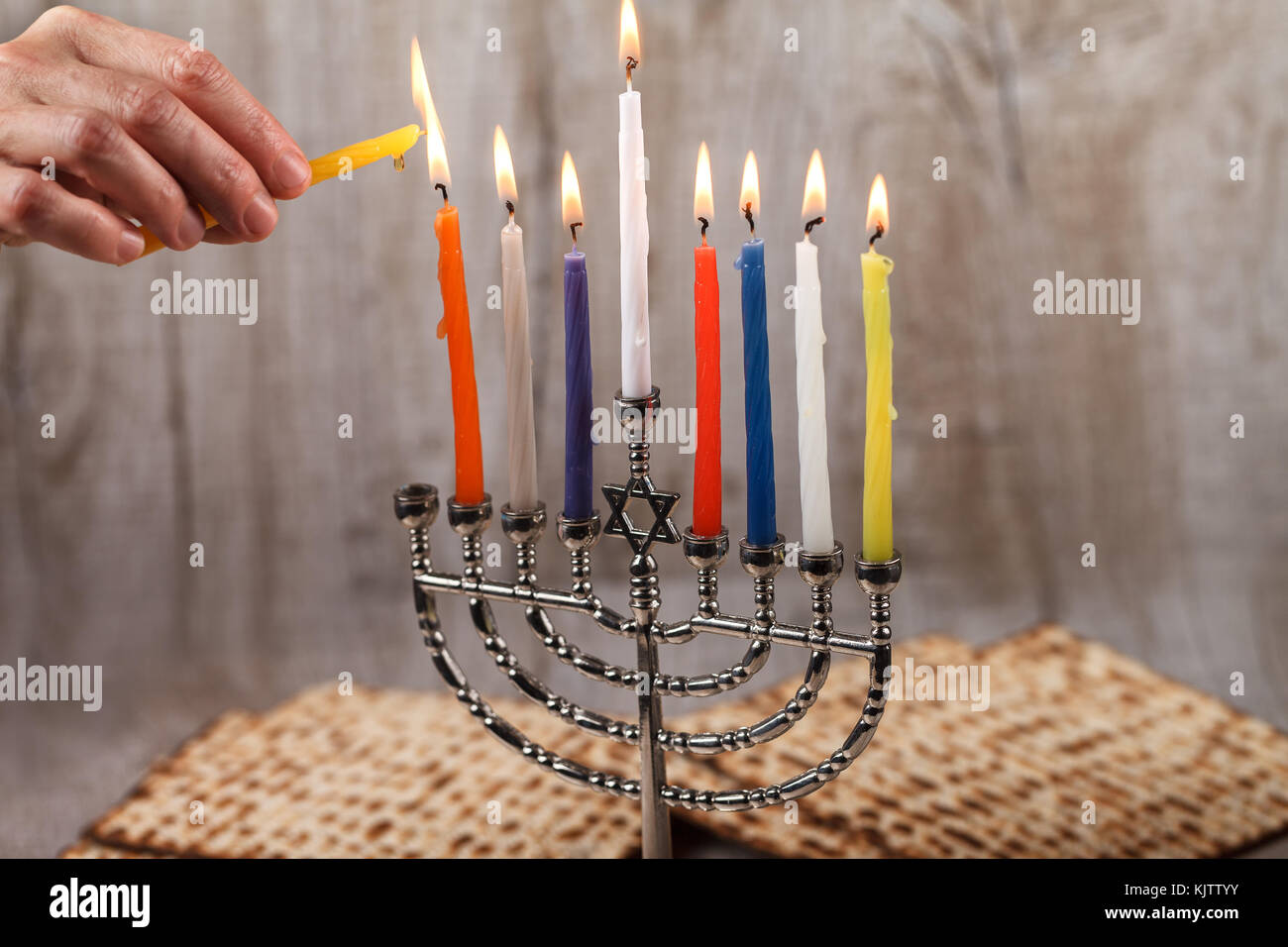 Menorah with candles for Hanukkah on a light wooden background. Matza ...