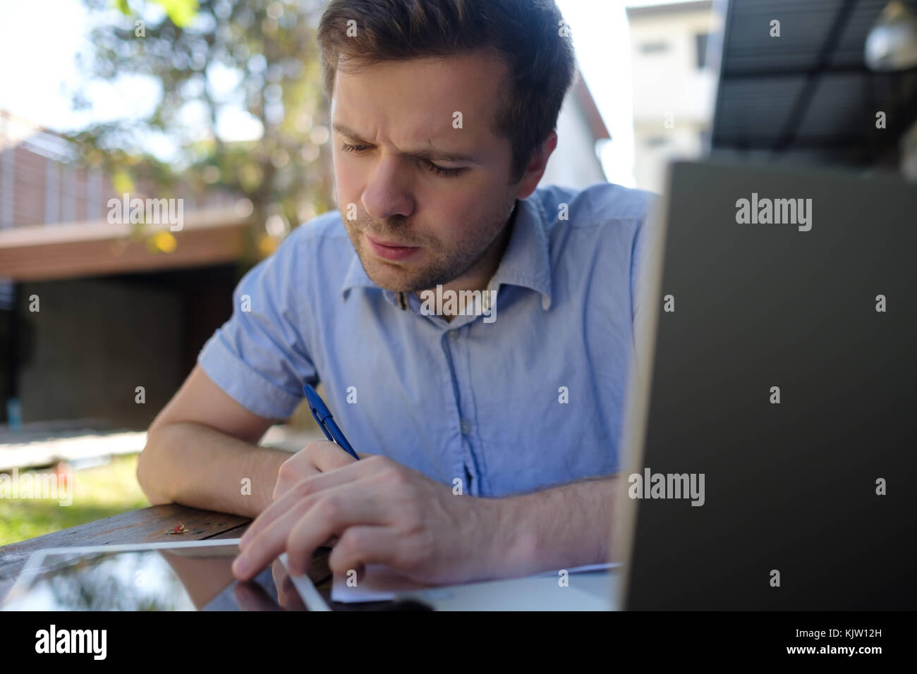 Smiling man working at home on laptop computer Stock Photo - Alamy