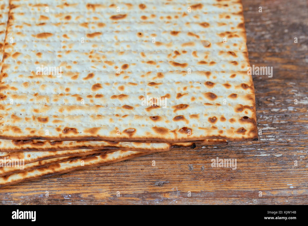 Jewish kosher matzah closeup on paper on a wooden table. horizontal ...