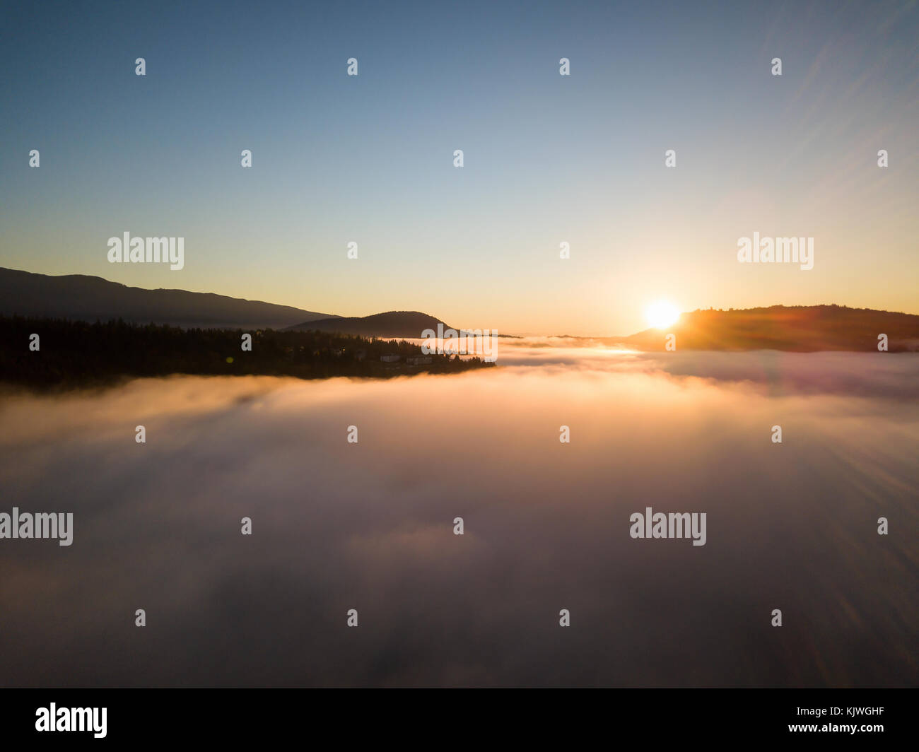 Beautiful aerial view of the ocean inlet covered in fog during a ...