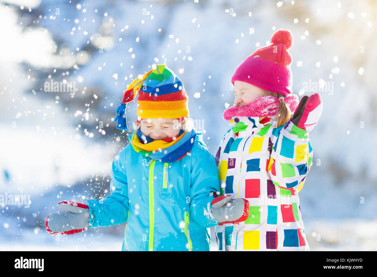 Kids playing in snow. Children play outdoors on snowy winter day. Boy ...