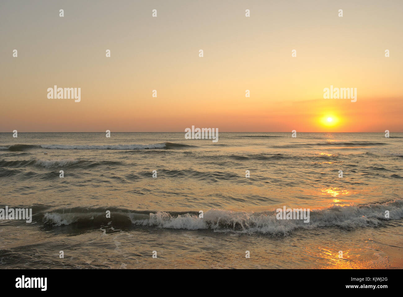 sunset reflected on the beach waves Stock Photo - Alamy