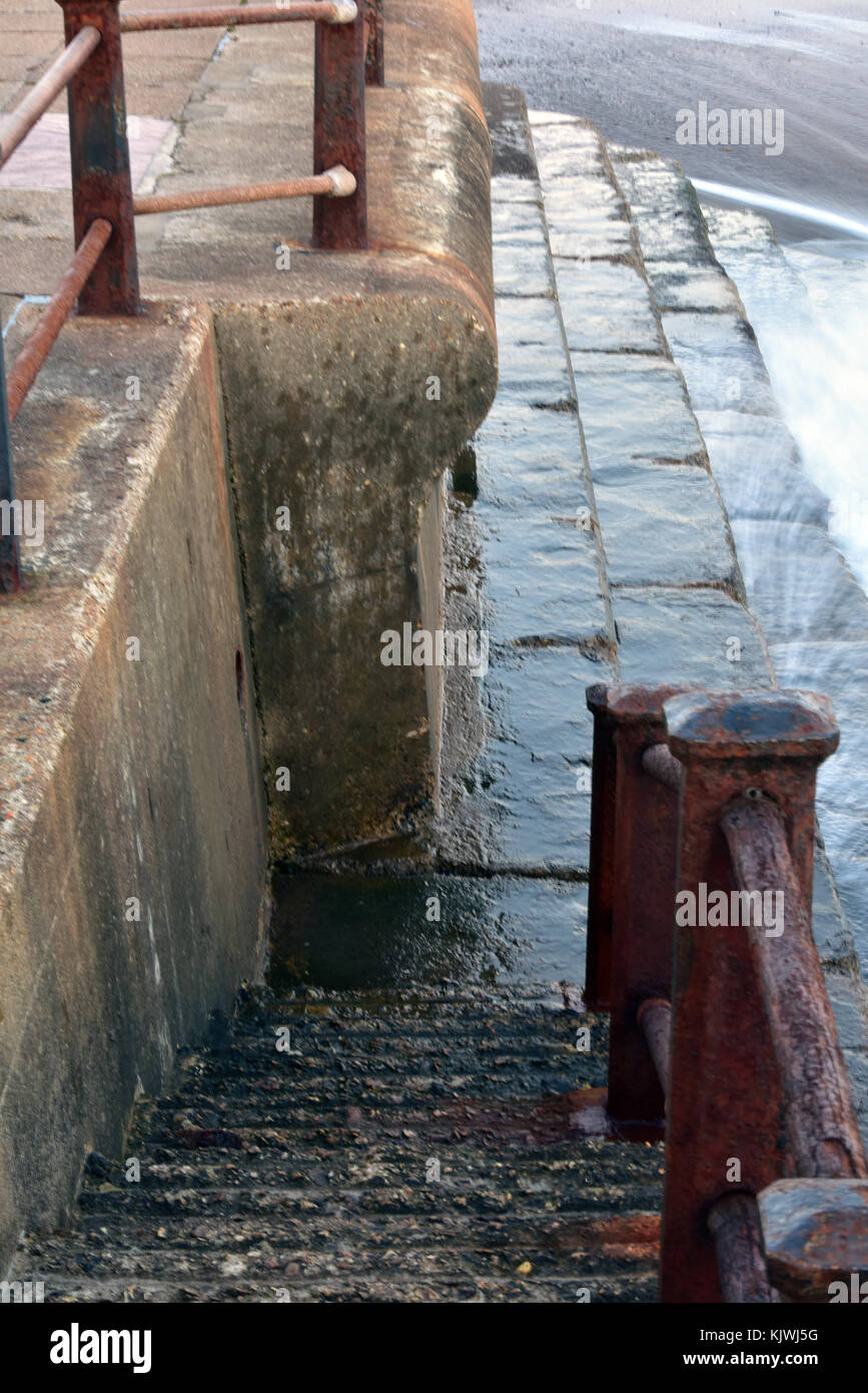 Some cold and wet stone steps or stairs from the seafront leading down ...