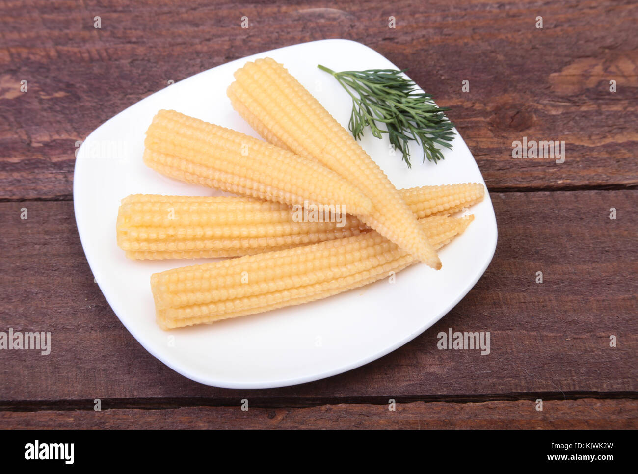 Mini Corn cob preserved on plate on wooden board Stock Photo - Alamy