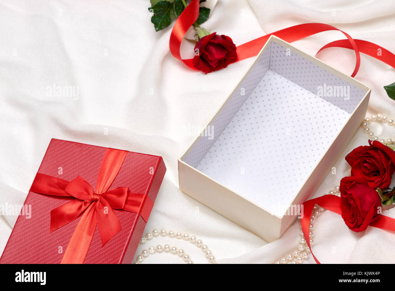 Open empty gift box. Red ribbon bow present with red roses on holiday ...