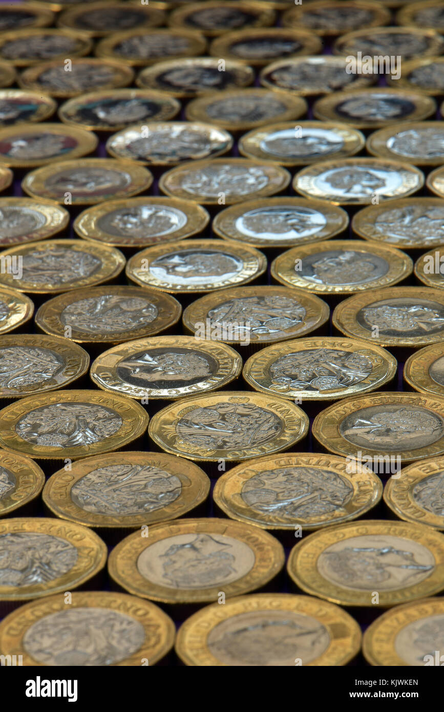 a large number or lots of one pound coins laid flat on a table together ...
