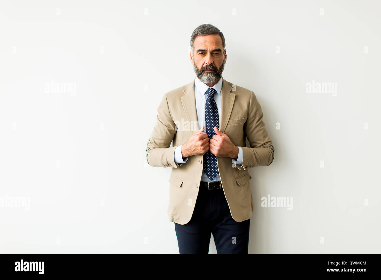 Portrait of bearded businessman by wall Stock Photo - Alamy