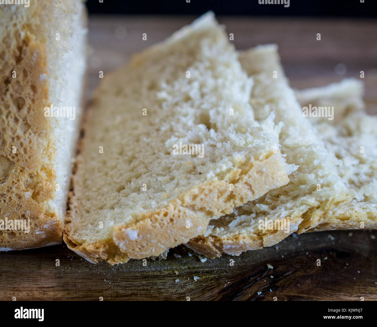 Closeup on sliced, machine-made white flour bread on wooden table Stock ...