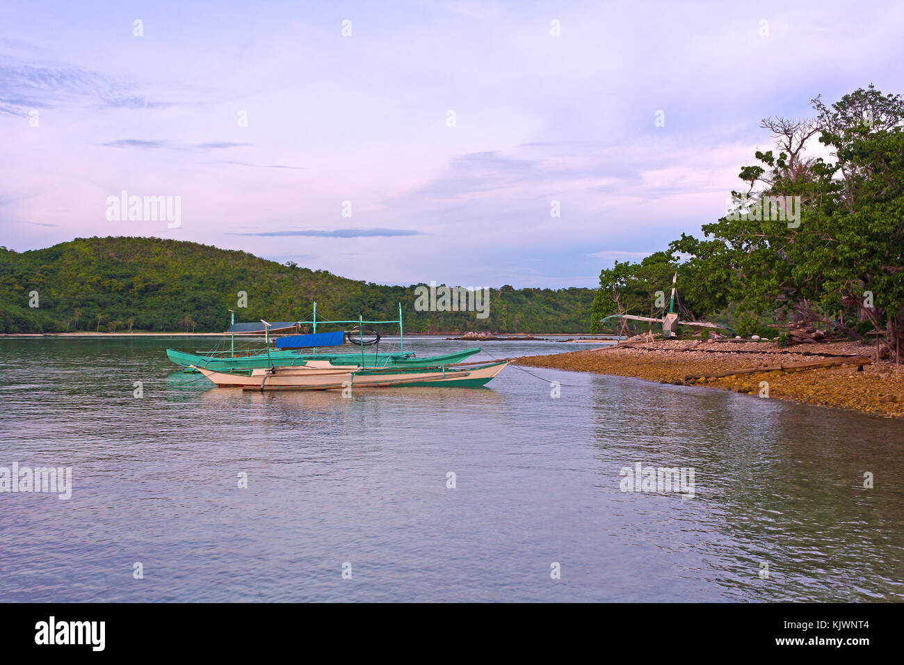 Traditional Pilipino boats moored in shallow waters of the sea lagoon ...