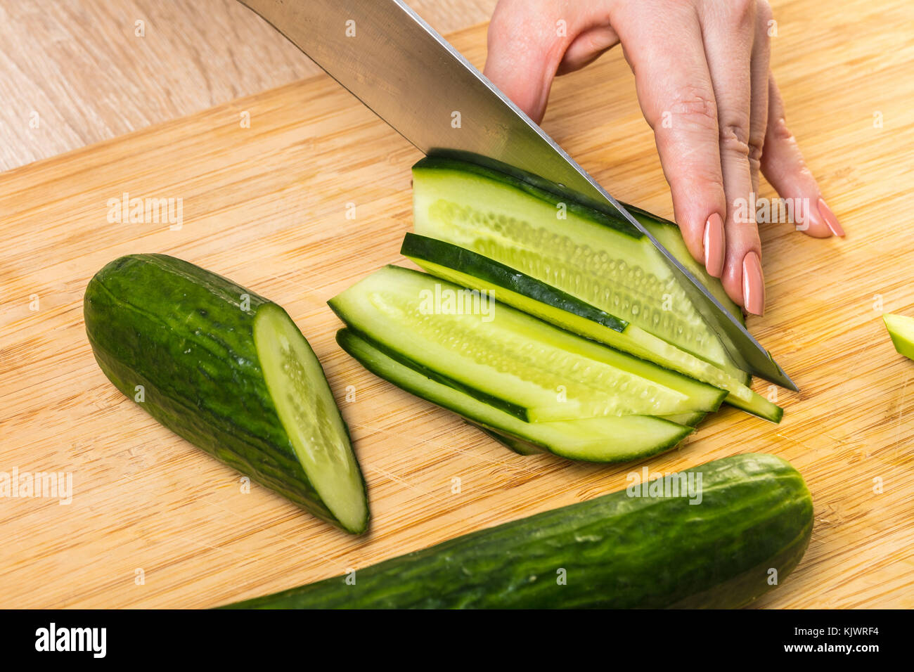 chef cuts cucumber with a knife, close-up hands Stock Photo - Alamy