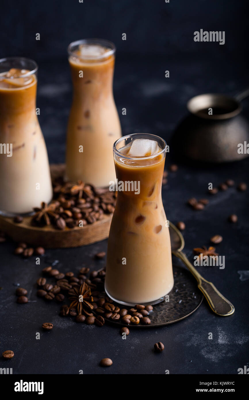 Three portions of coffee with milk and ice over dark background Stock ...