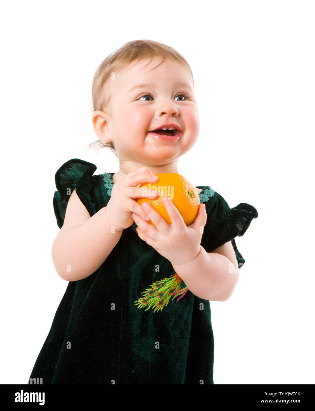 Happy child holding orange looking up smiling isolated Stock Photo - Alamy