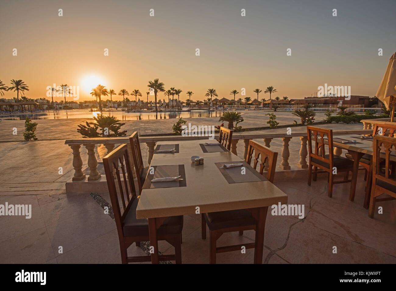 Outdoor dining terrace area with table set up on tropical ocean beach ...
