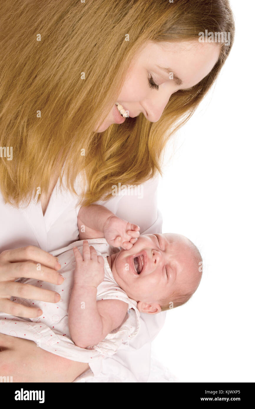 Happy mother holding her crying baby isolated Stock Photo - Alamy