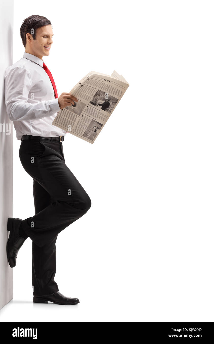 Full length profile shot of an elegant guy reading a newspaper and ...