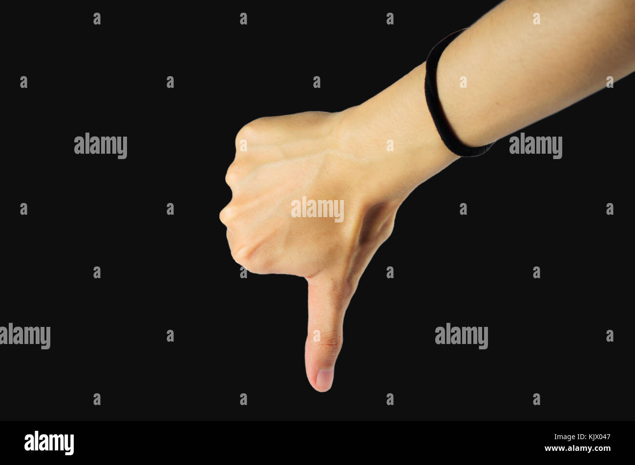 Beautiful female hand thumb down isolated on black background, asian ...