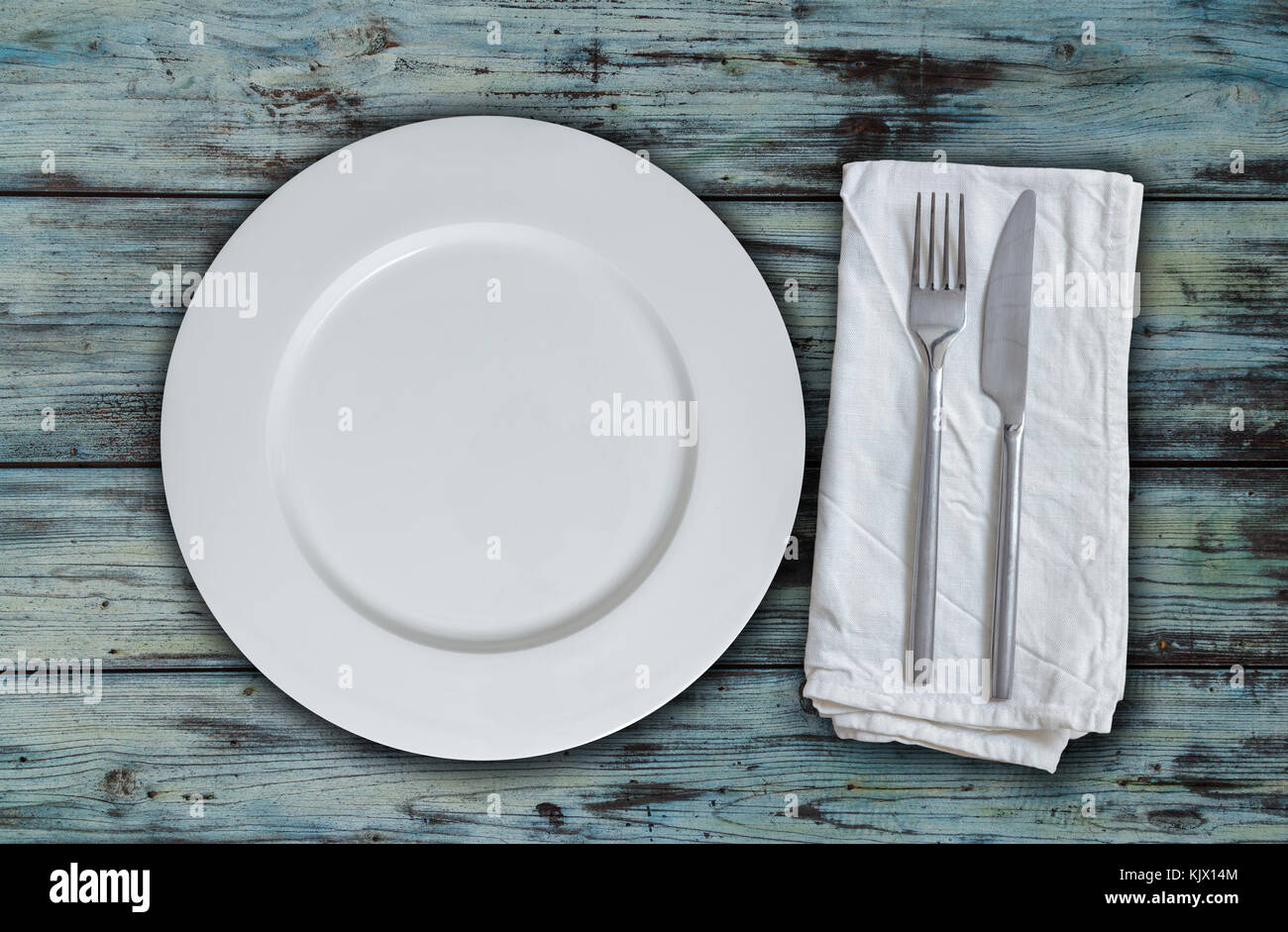 Empty plate and cutlery on used look wood Stock Photo - Alamy