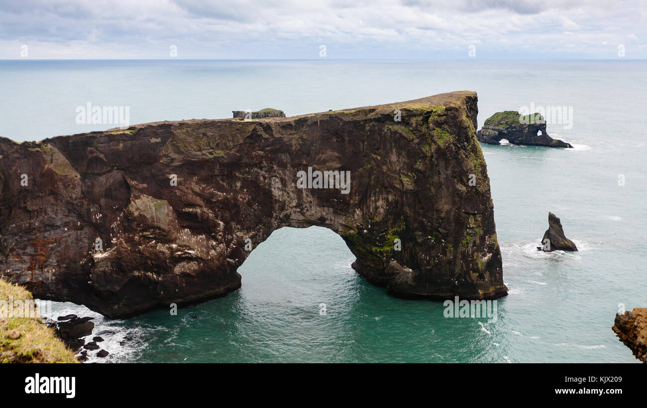 travel to Iceland - view of stone arch on Dyrholaey peninsula, near Vik ...