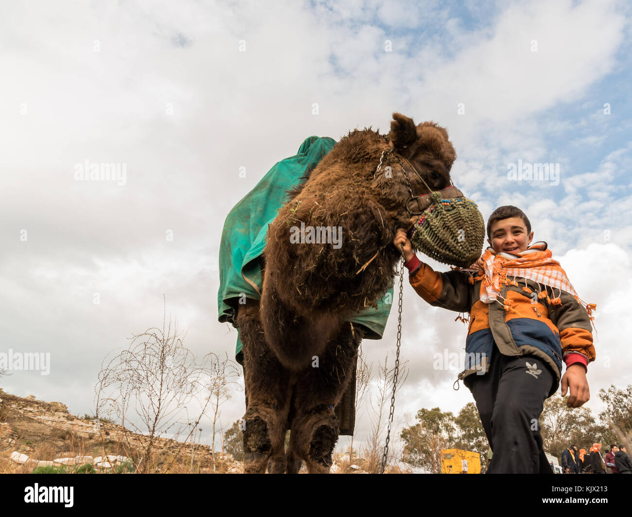 A Turkish child dressed in local clothes posing in front of camel that ...