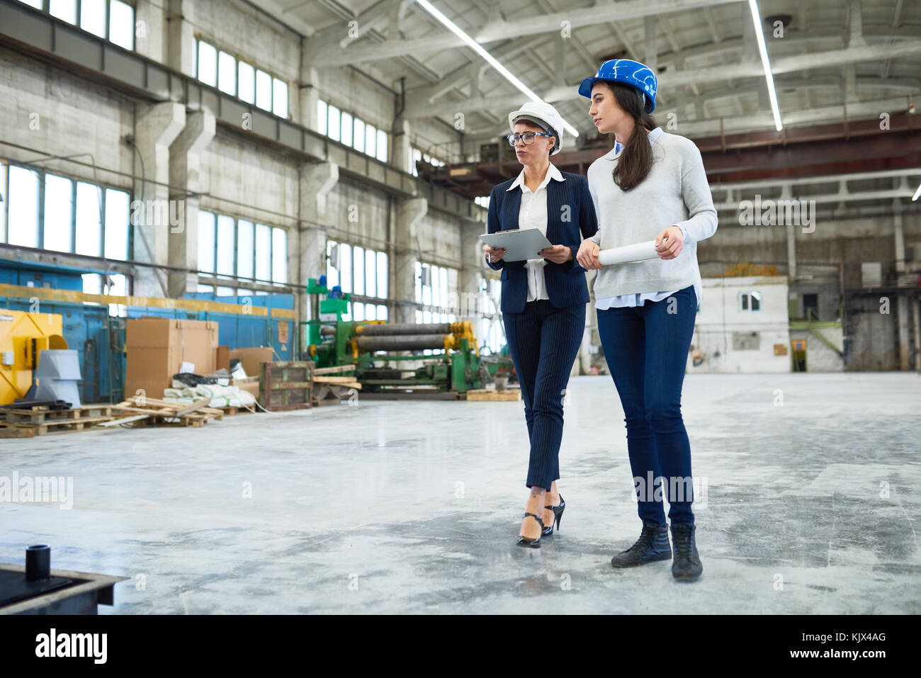 Confident female forewoman presenting new equipment to building ...