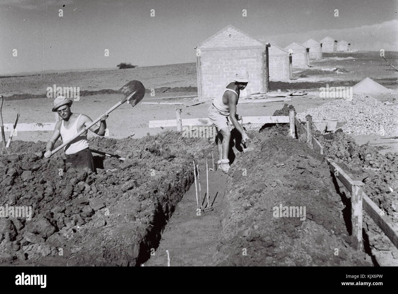 BUILDING WORKERS LAYING THE FOUNDATION FOR ONE OF THE NEW HOUSES AT ...