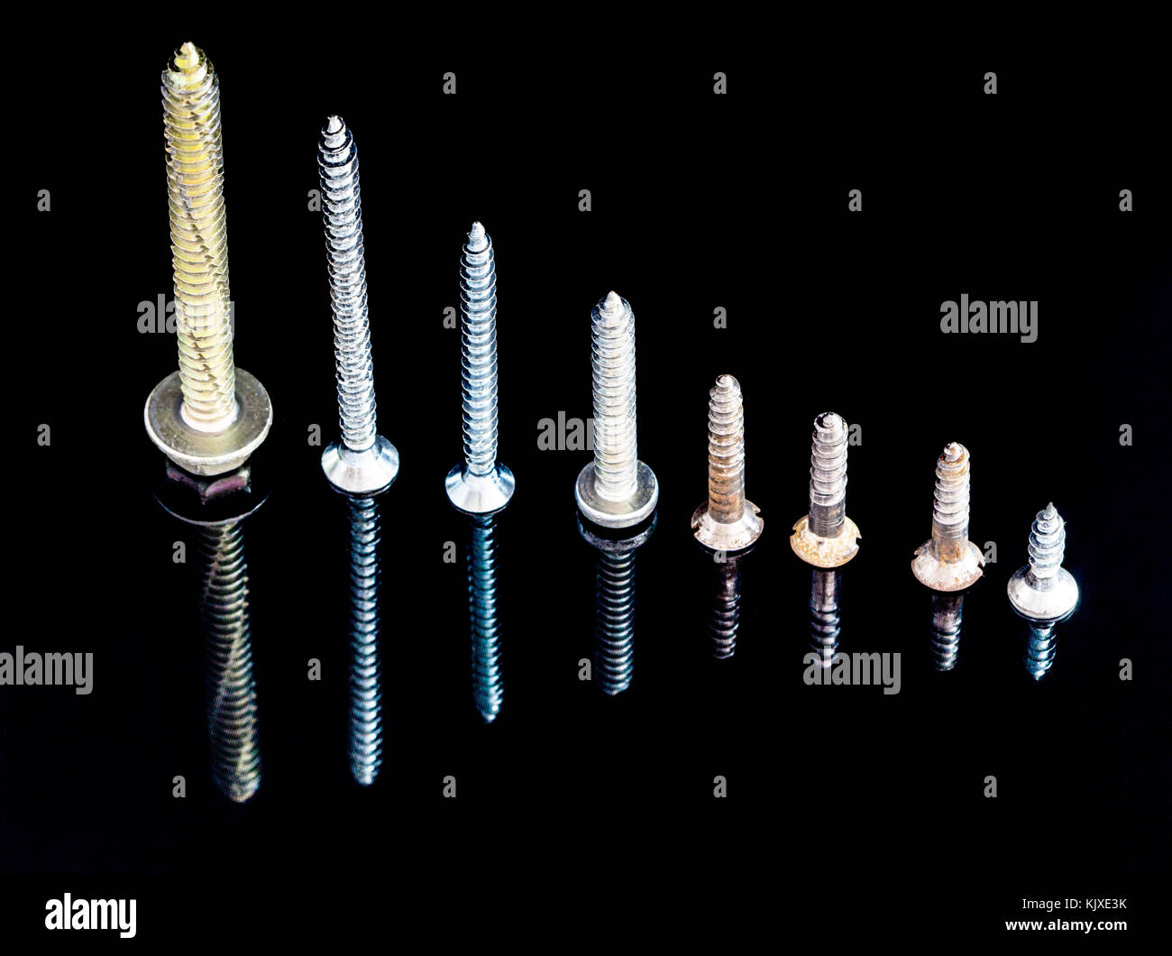 Various screws on a black background with reflection, City of screws ...