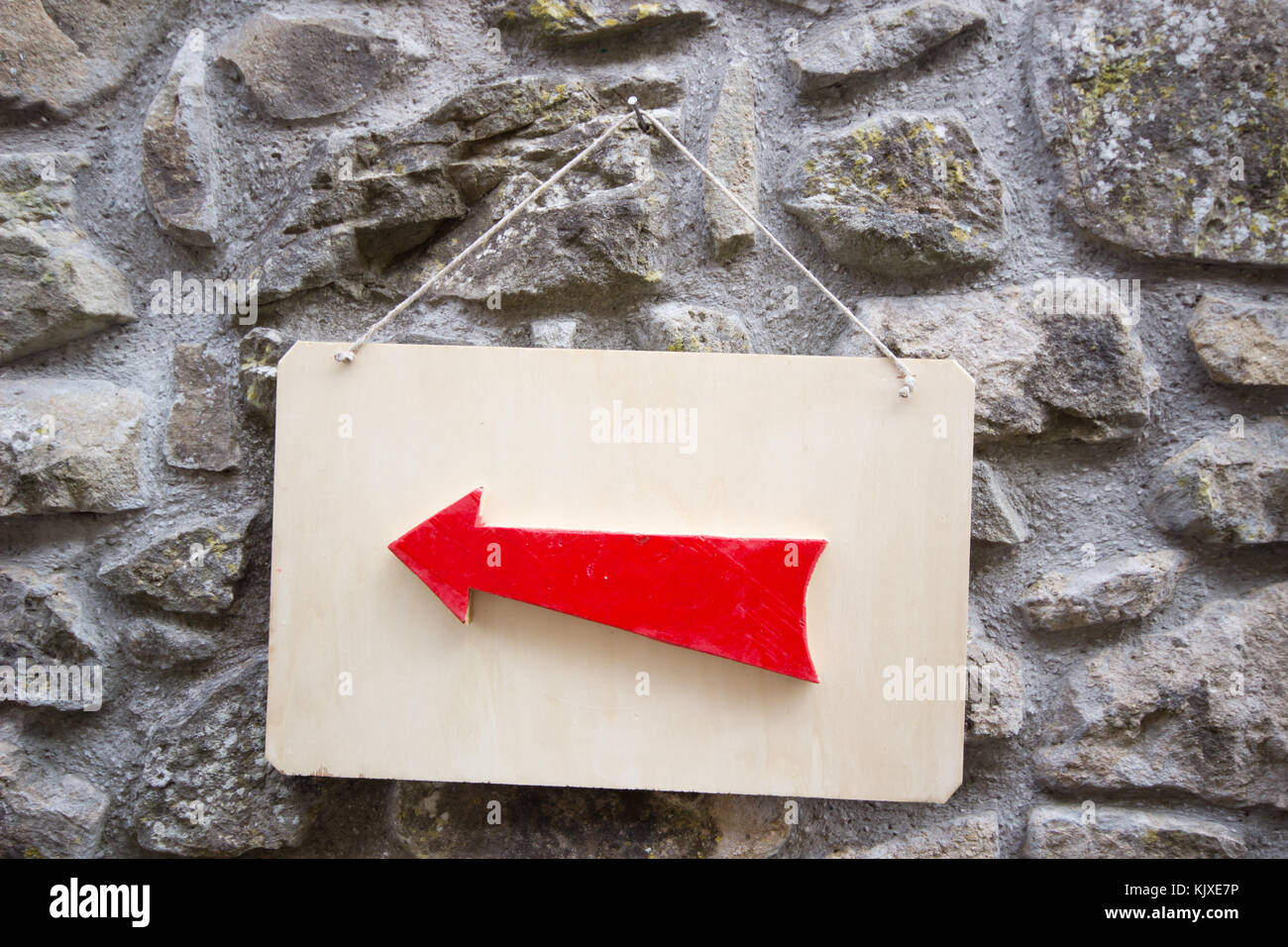 Red wood arrow hanging on the wall signpost for your needs. Red wooden ...
