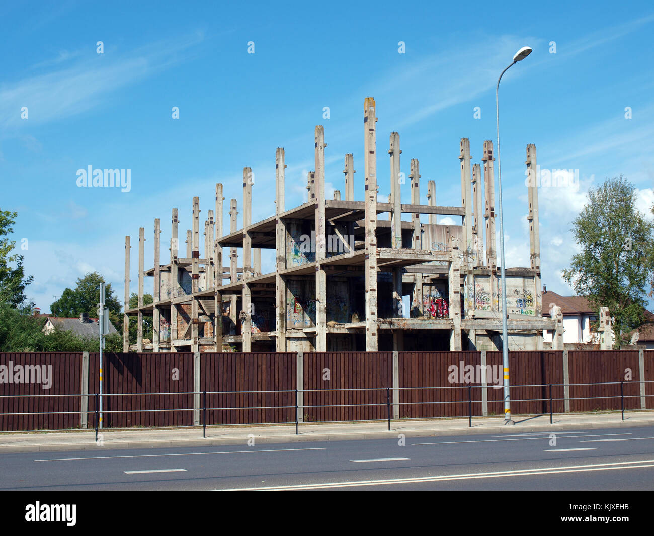 Partly demolished building columns behind the fence Stock Photo - Alamy