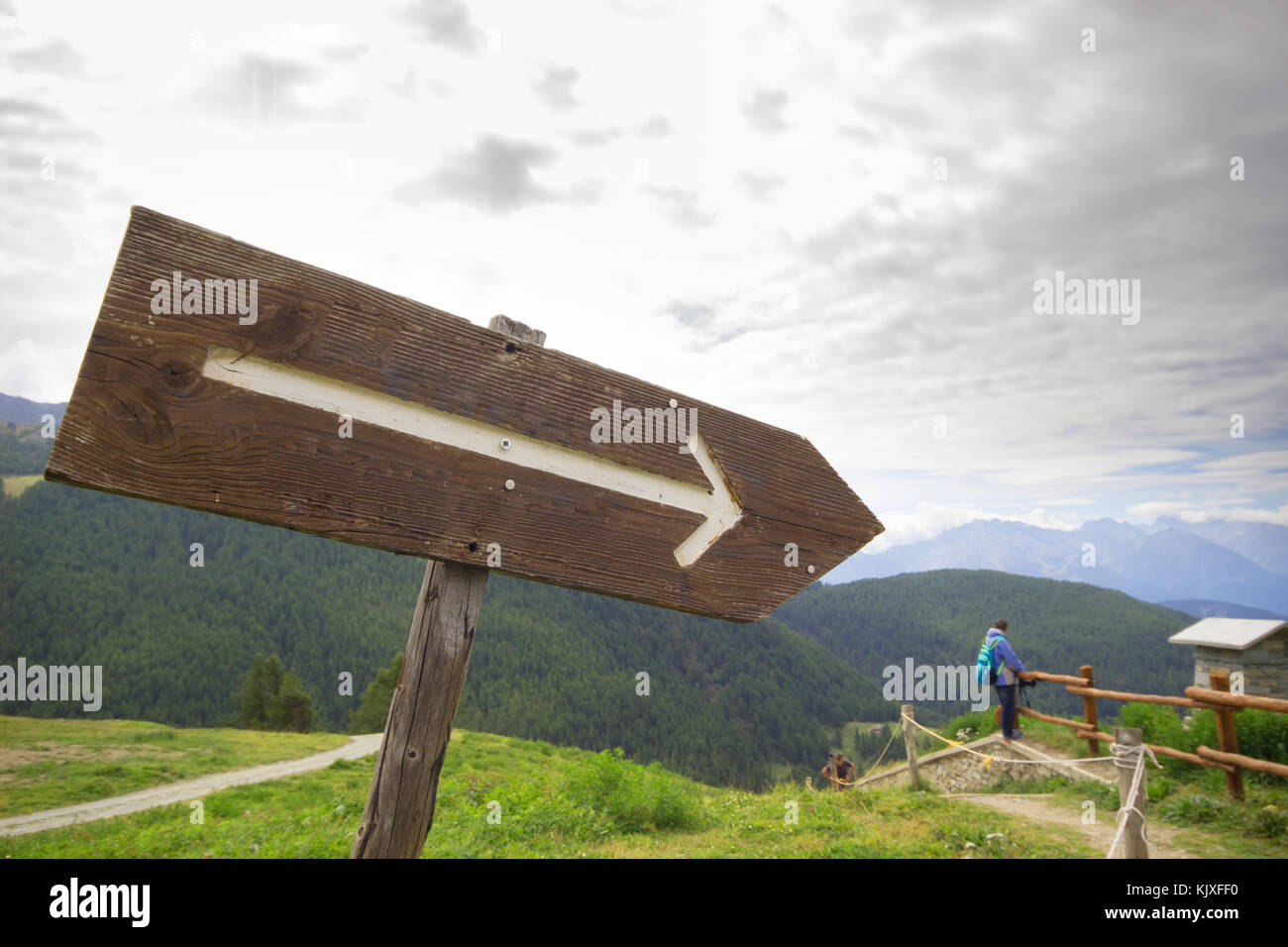 Wooden sign with symbol arrow in mountain nature summer background ...