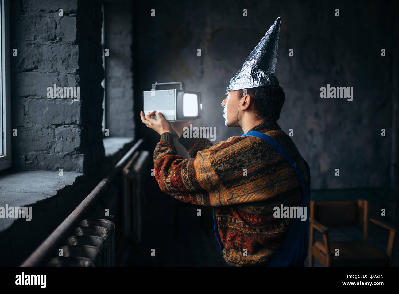 Paranoid man in tinfoil cap watch TV, mind protection from telepathy ...