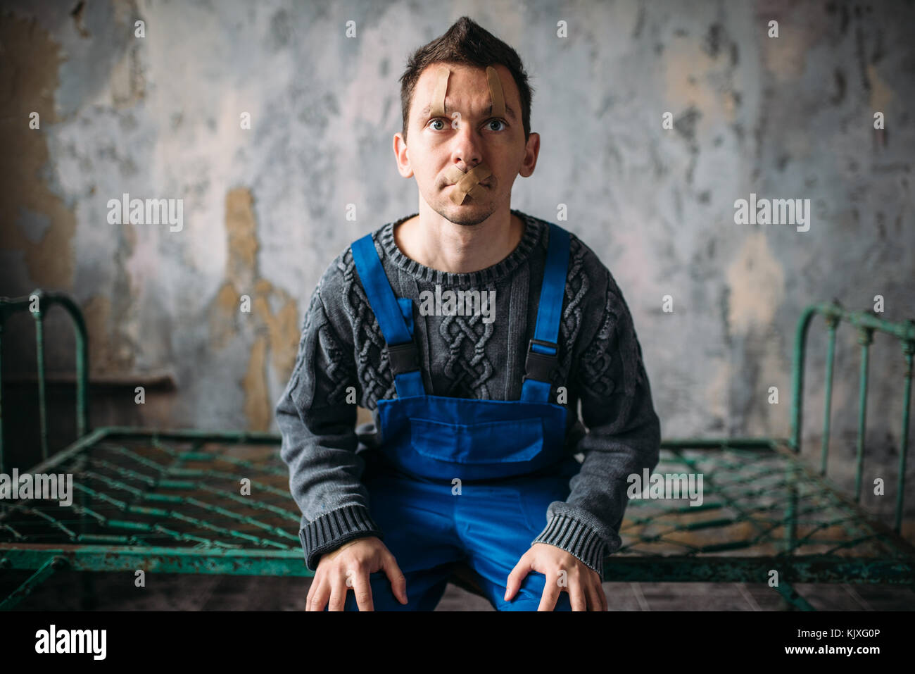 Madman in uniform mouth sealed with plaster, psycho patient. Mentally ...