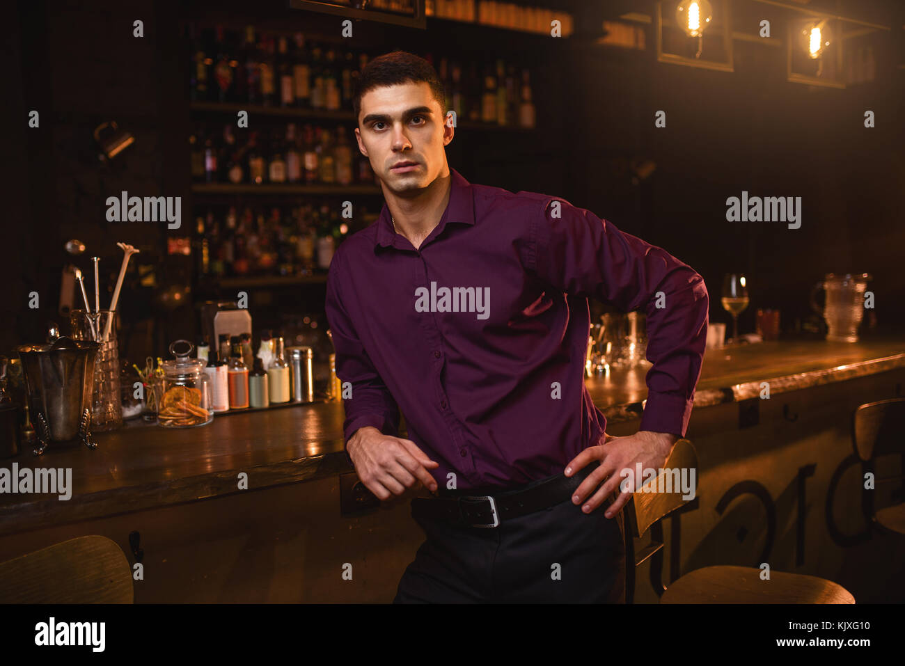 Young elegant man in shirt standing at the bar counter. Night lifestyle ...