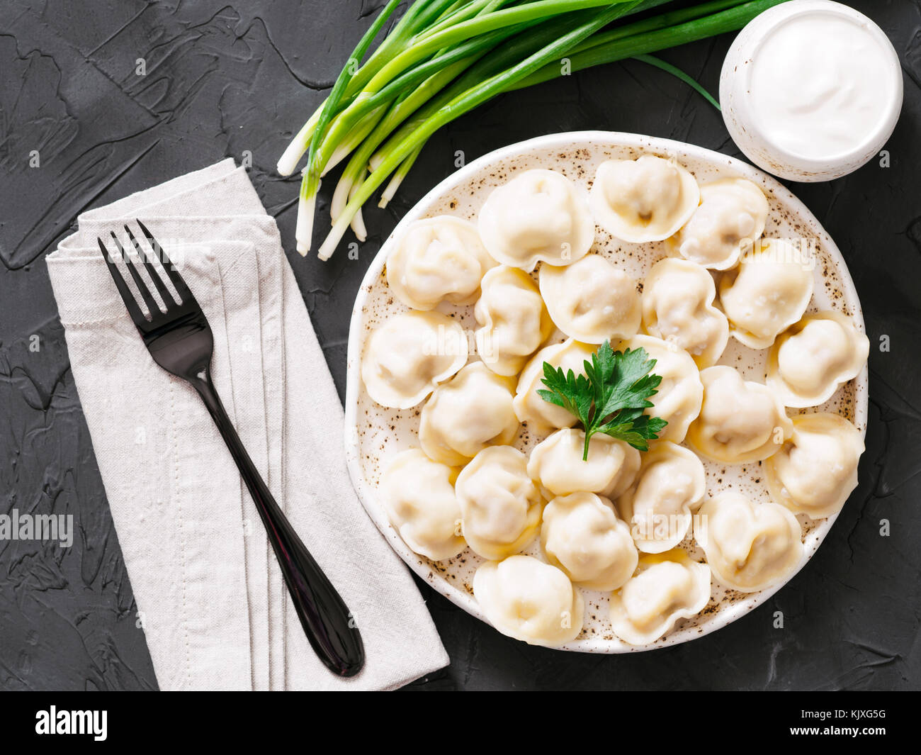 Traditional russian pelmeni, ravioli, dumplings with meat on black ...