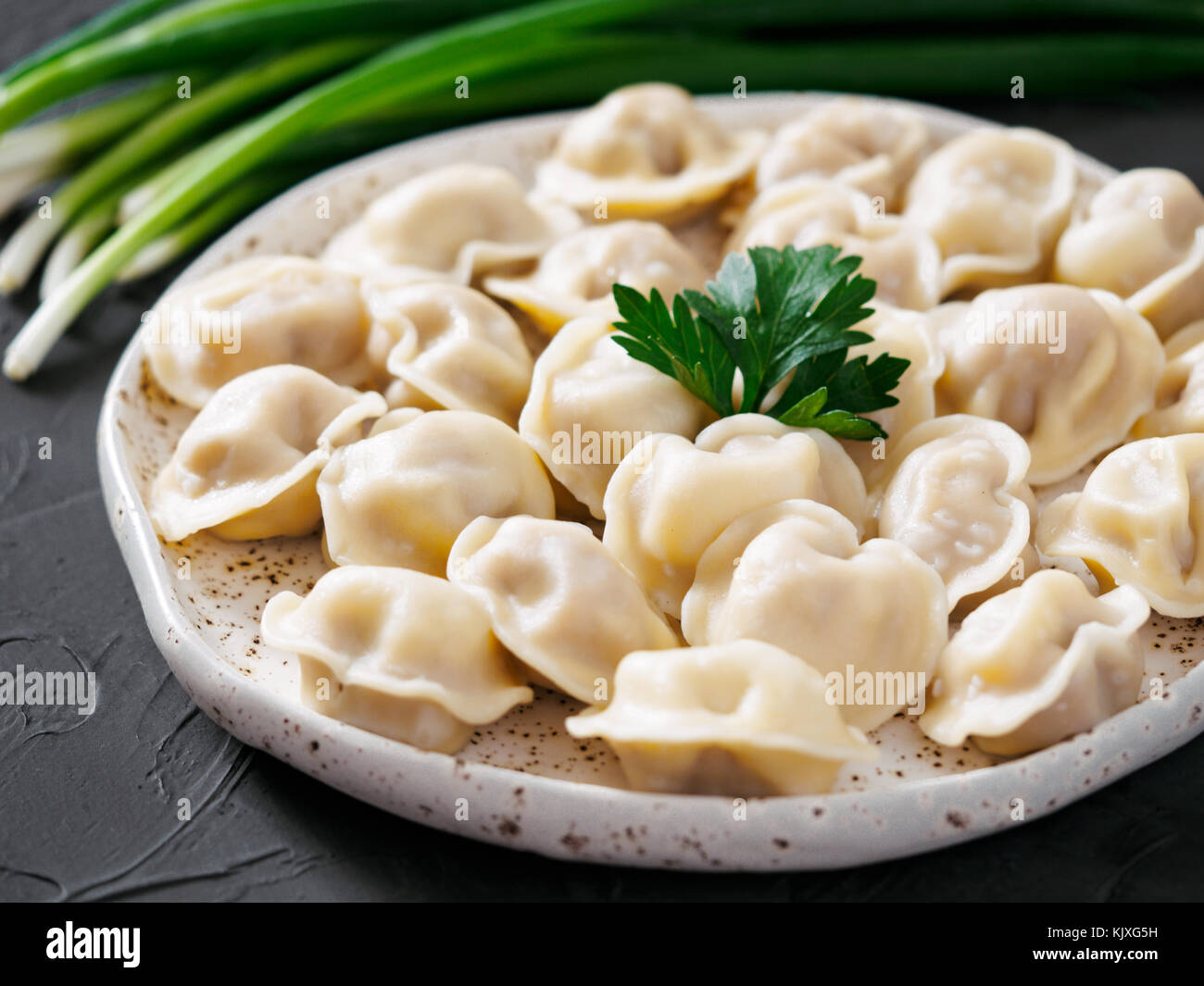 Traditional russian pelmeni, ravioli, dumplings with meat on black ...