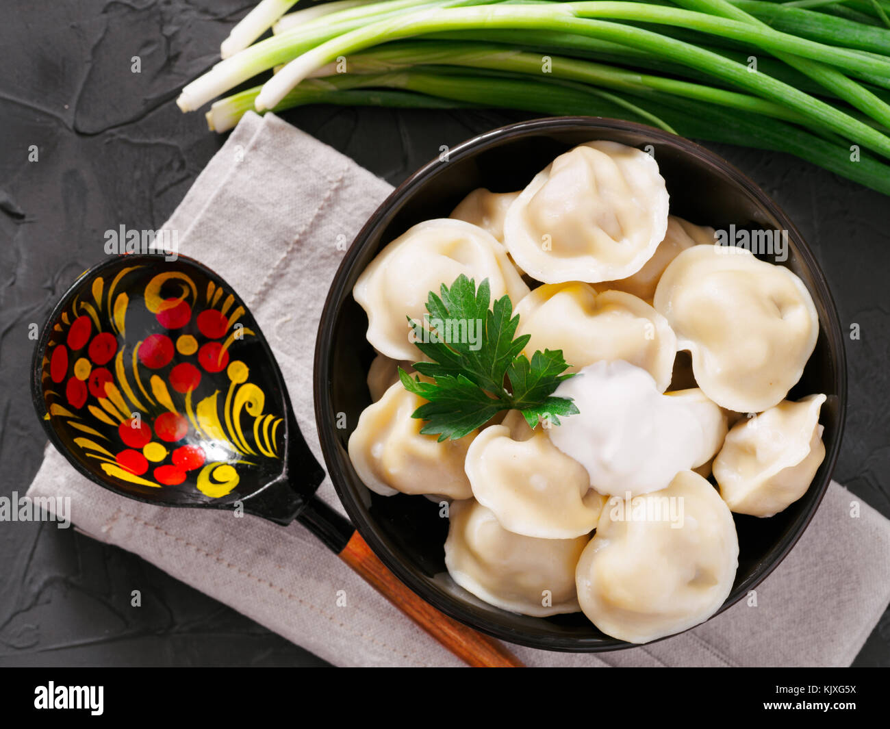 Traditional russian pelmeni, ravioli, dumplings with meat on black ...
