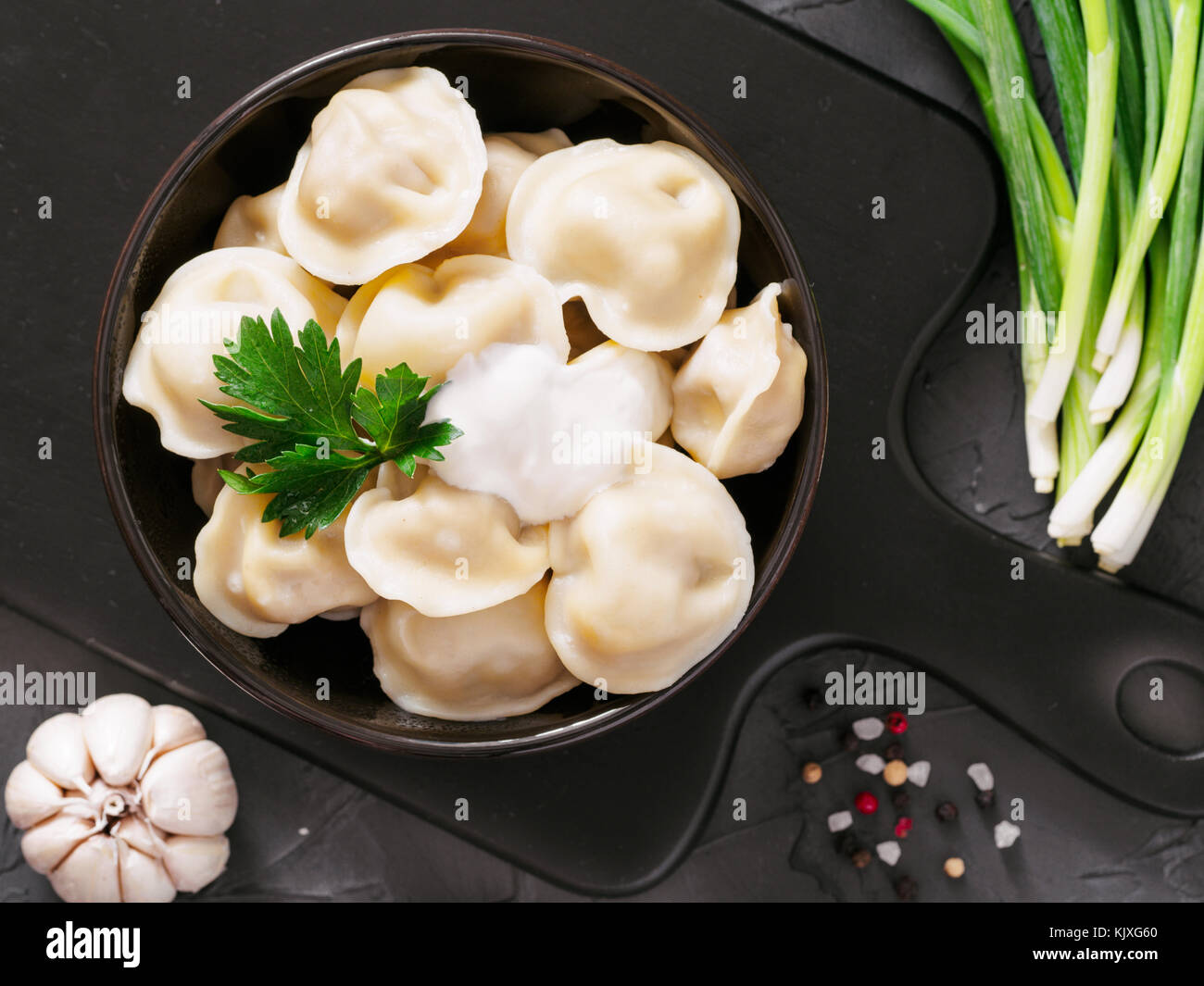 Traditional russian pelmeni, ravioli, dumplings with meat on black ...