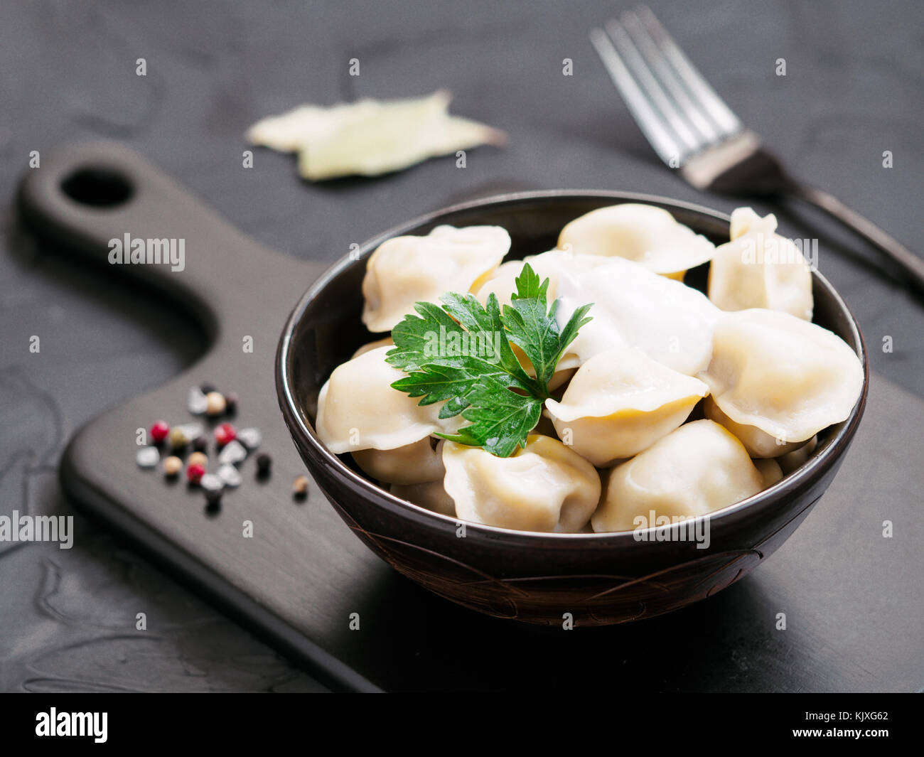 Traditional russian pelmeni, ravioli, dumplings with meat on black ...